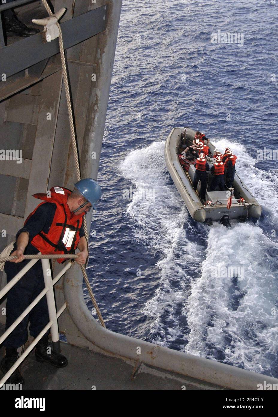 US Navy Sailors pull up lines after lowering a Rigid Hull Inflatable ...