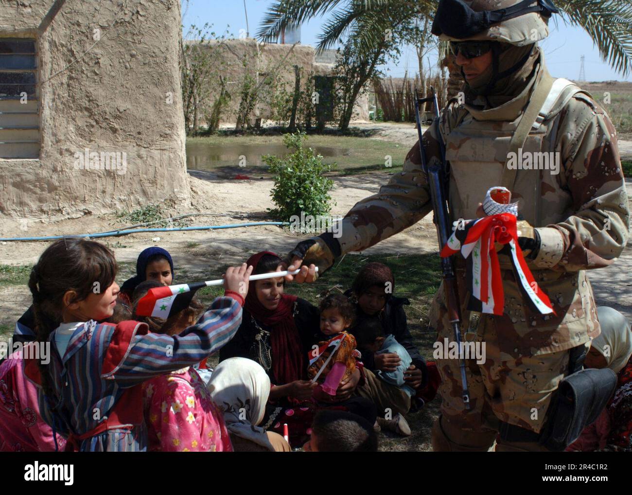 US Navy An Iraqi soldier gives an Iraqi flag to a little girl as her ...