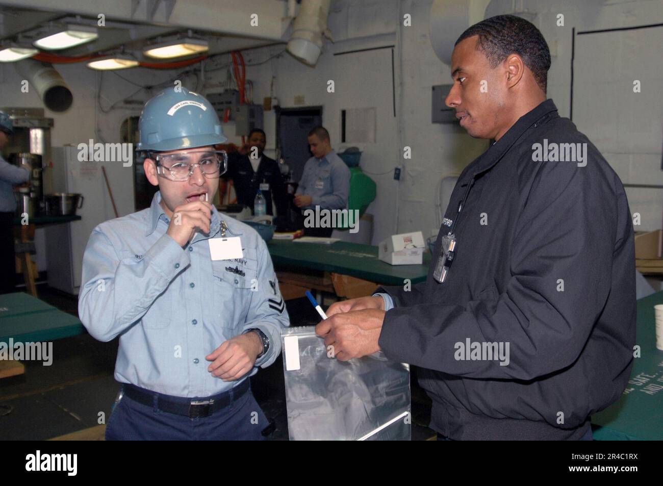 US Navy Machinist Mate 2nd Class takes a DNA sample from his mouth with ...