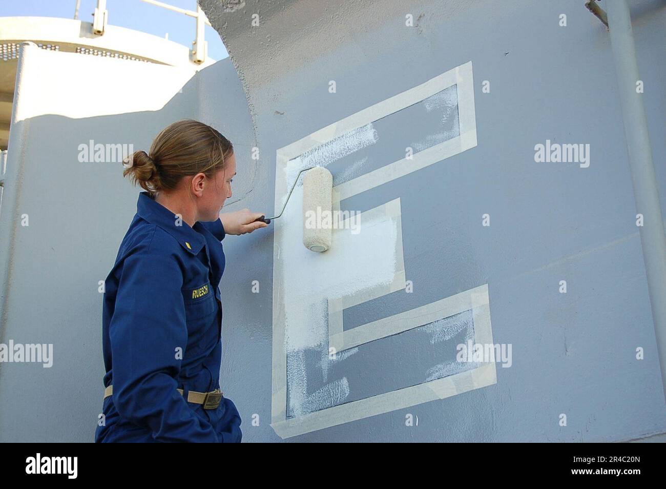 US Navy Ensign paints the Navy Battle E on the amphibious transport ...