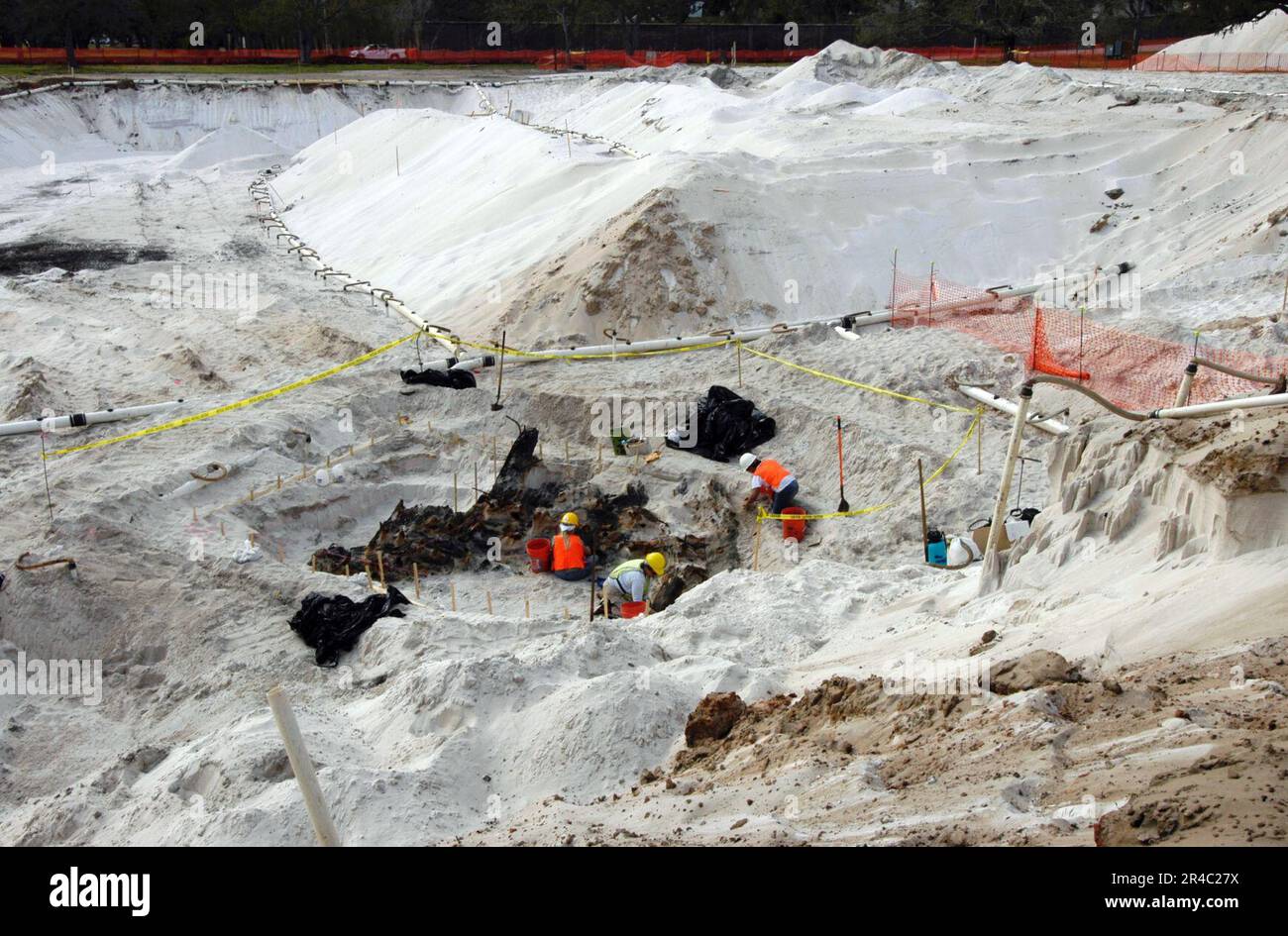 US Navy Archaeologists carefully clear sand from the remains of what is ...