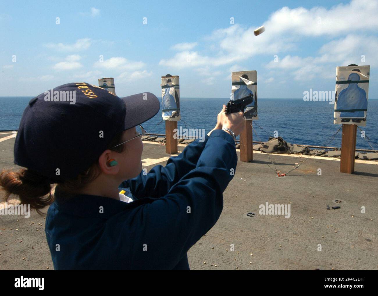 US Navy Ensign fires a 9mm pistol at a target during small arms ...