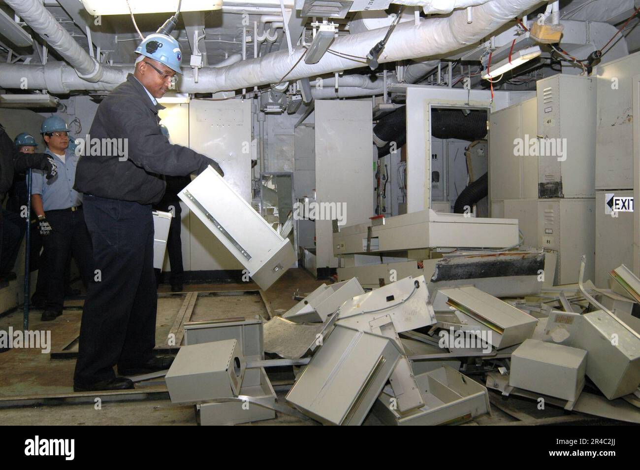 US Navy Petty Officer 3rd Class places a drawer from a personal storage ...
