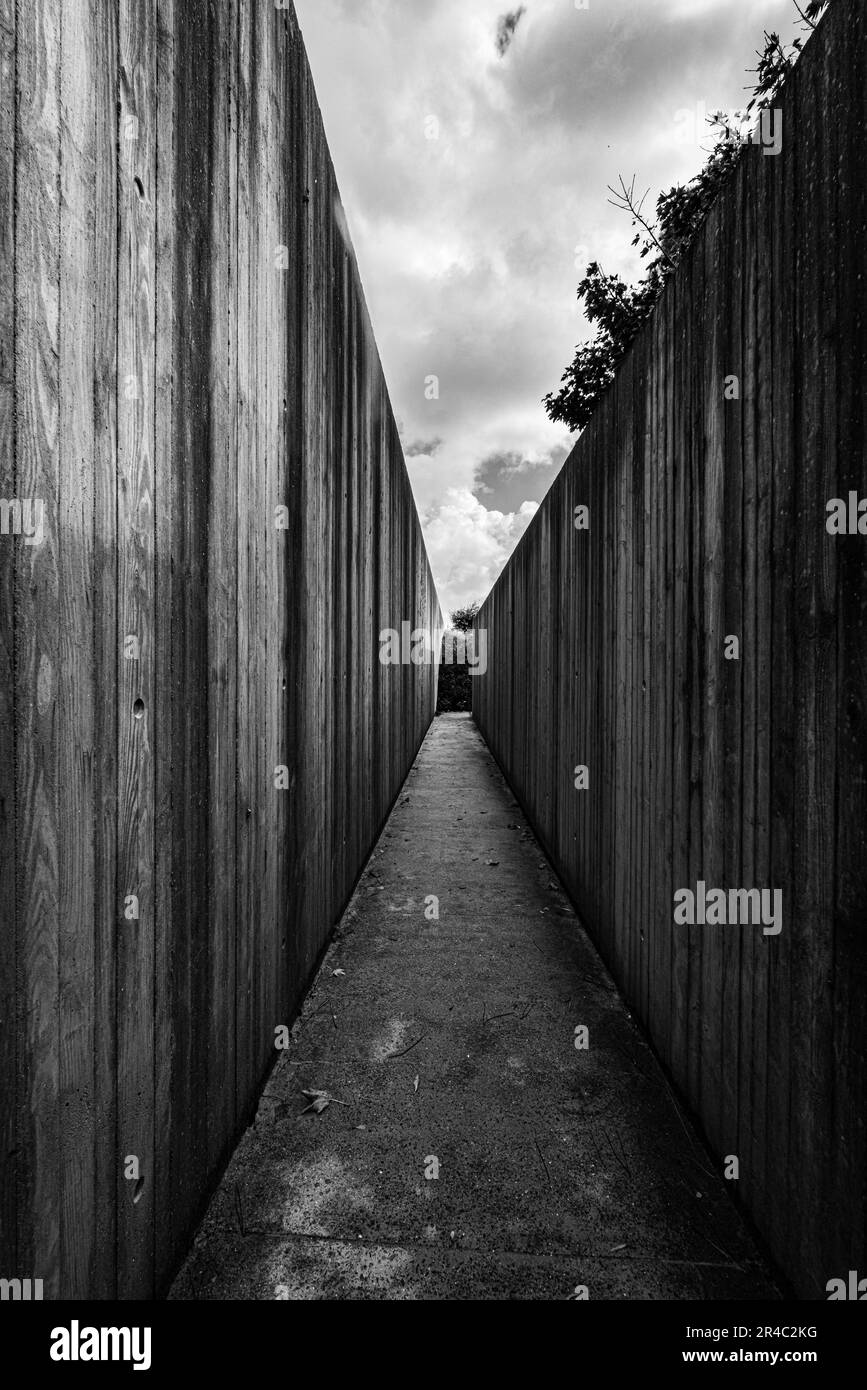 An illuminated urban street with concrete walls on either side, devoid ...