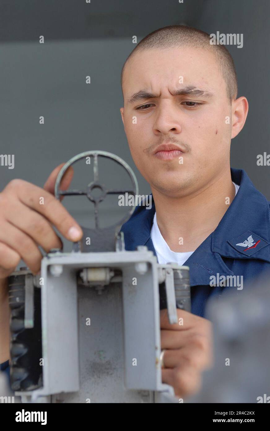 US Navy Aviation Ordnanceman 3rd Class checks the alignment of the gun ...