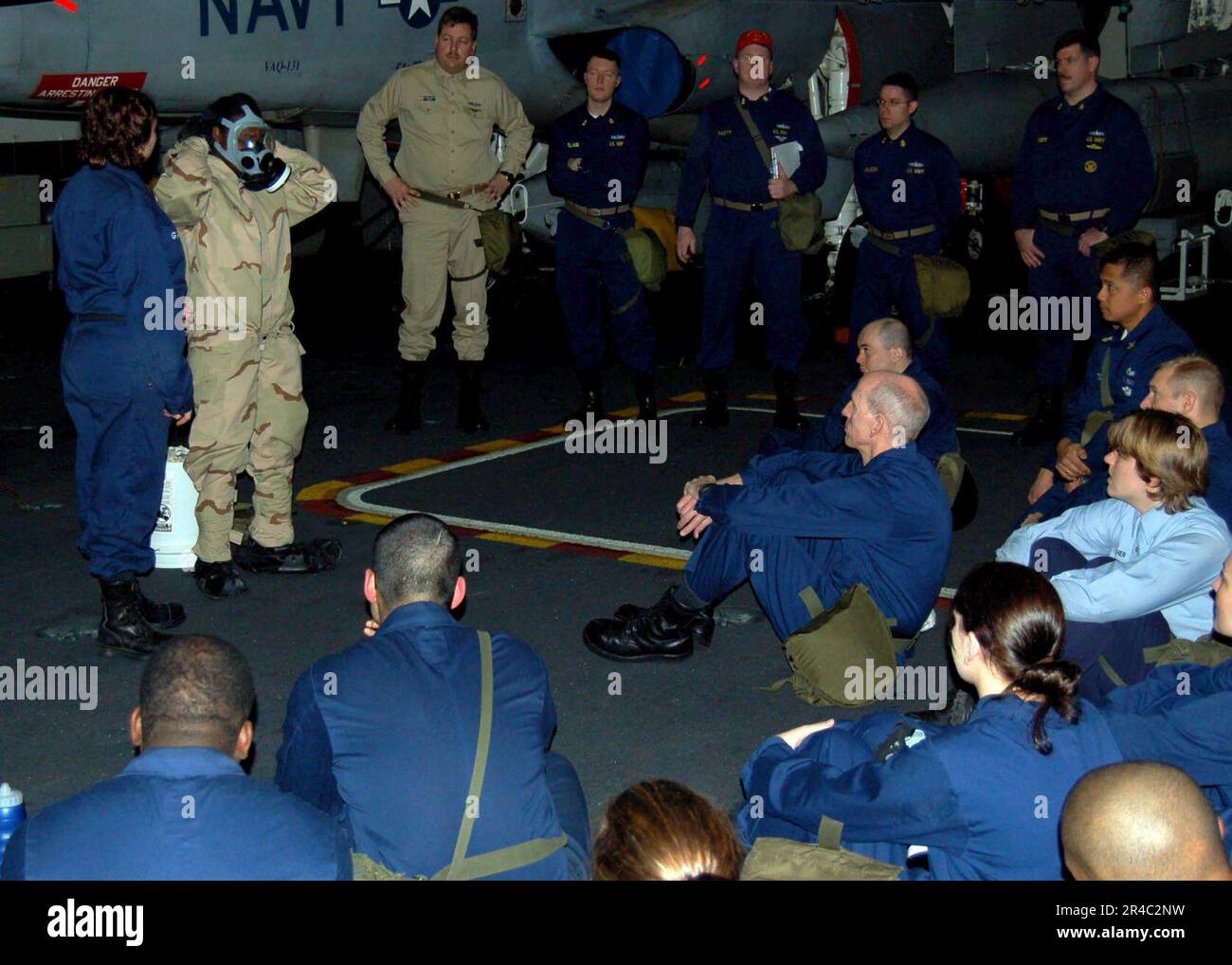 US Navy Hull Technician 2nd Class left, explains how to don an Advanced ...