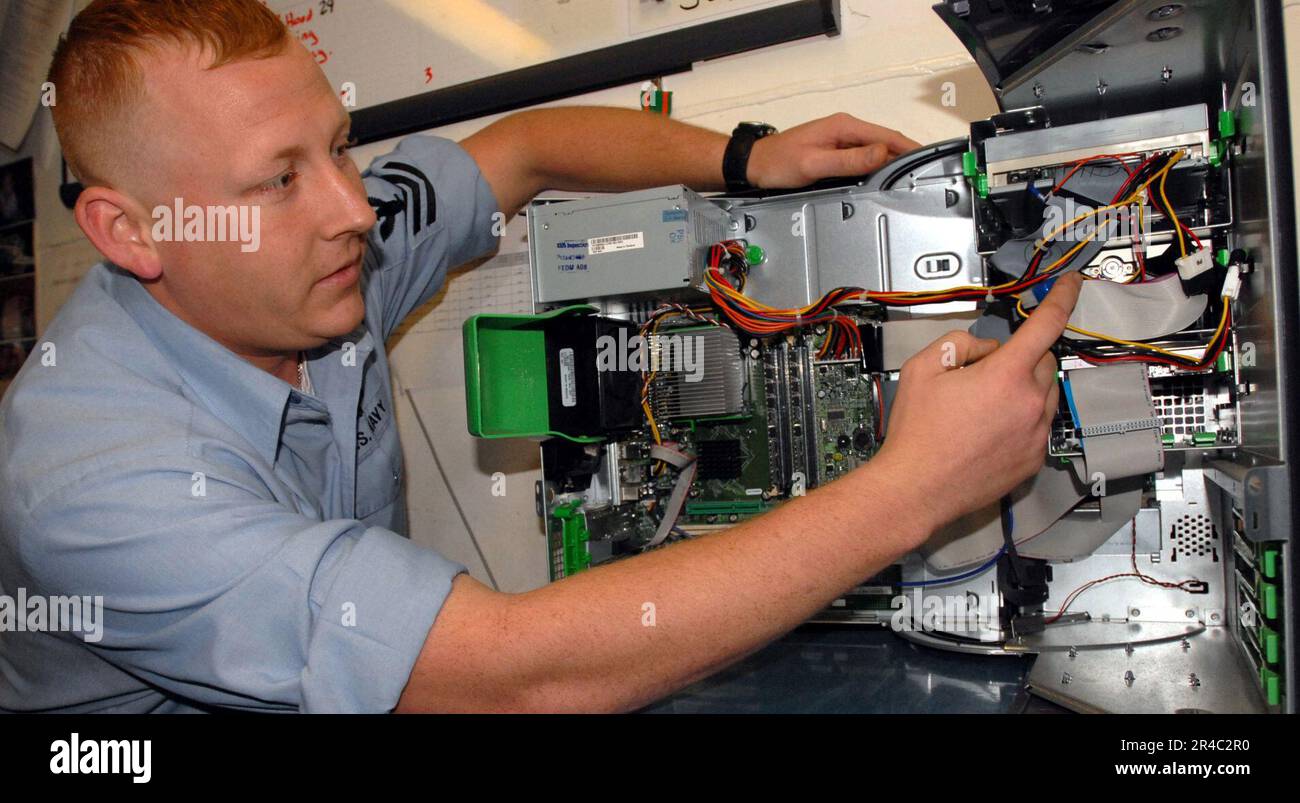 US Navy Information Systems Technician 1st Class inspects the internal ...