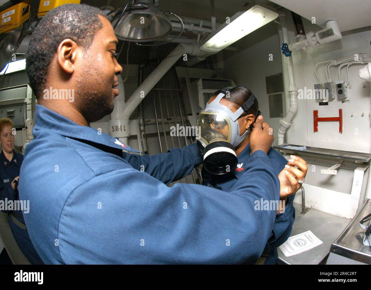 US Navy Yeoman 3rd Class helps Yeoman 2nd Class adjust the straps on an ...