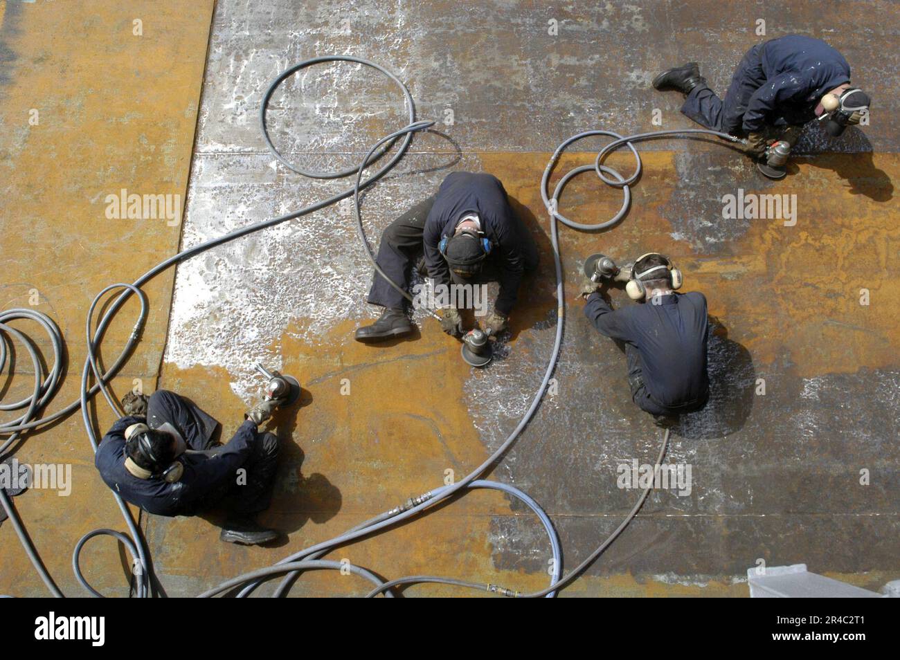 US Navy Combat Systems Department Sailors use grinders to smooth the ...