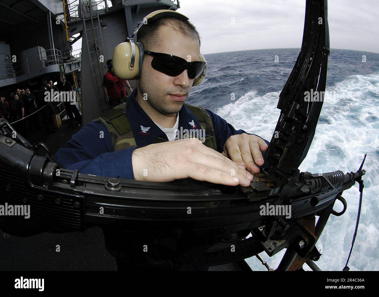 US Navy Aviation Ordnanceman 3rd Class loads ammunition into an M-60 ...