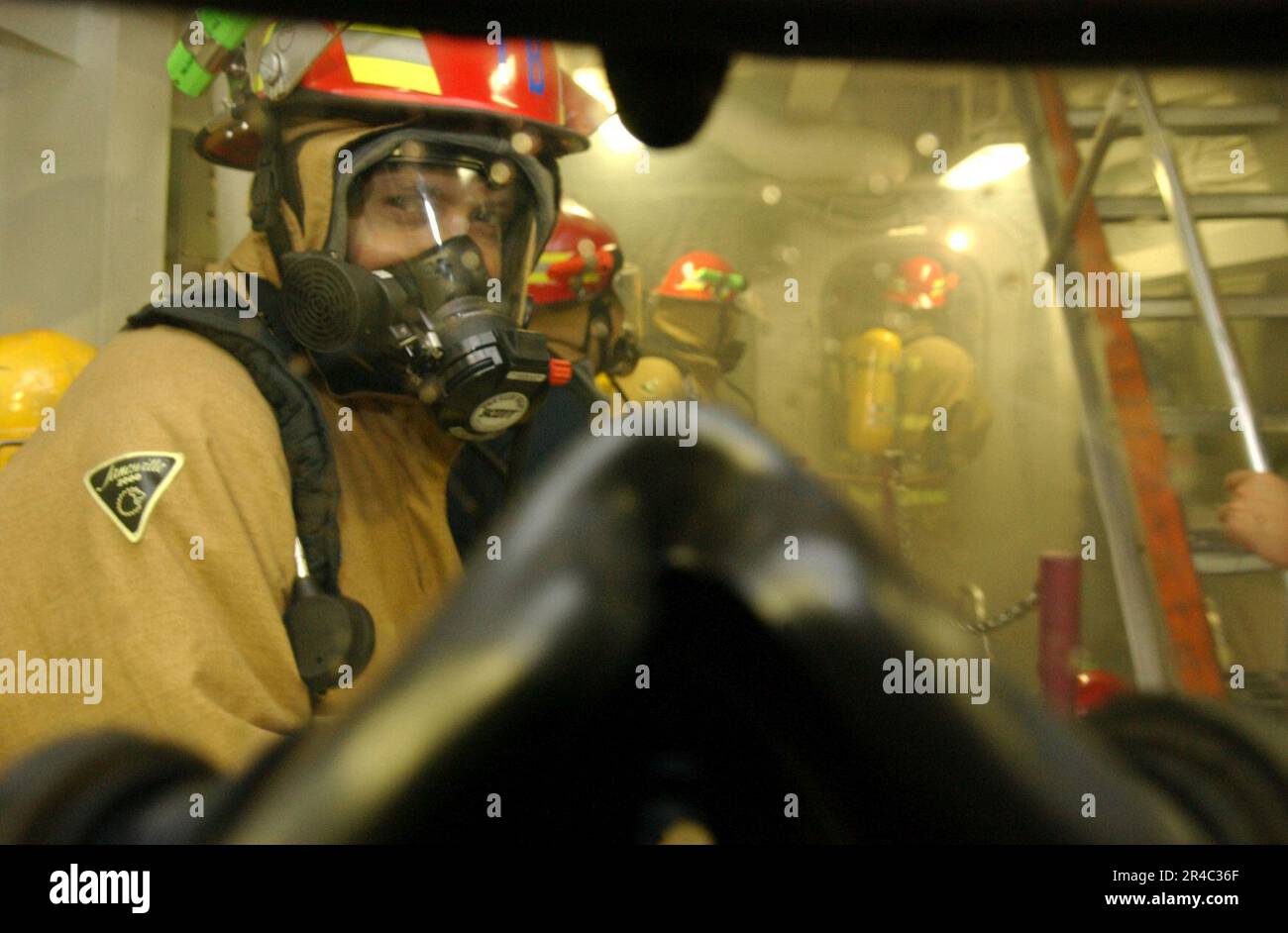 US Navy Seaman looks over his shoulder to relay information about a ...