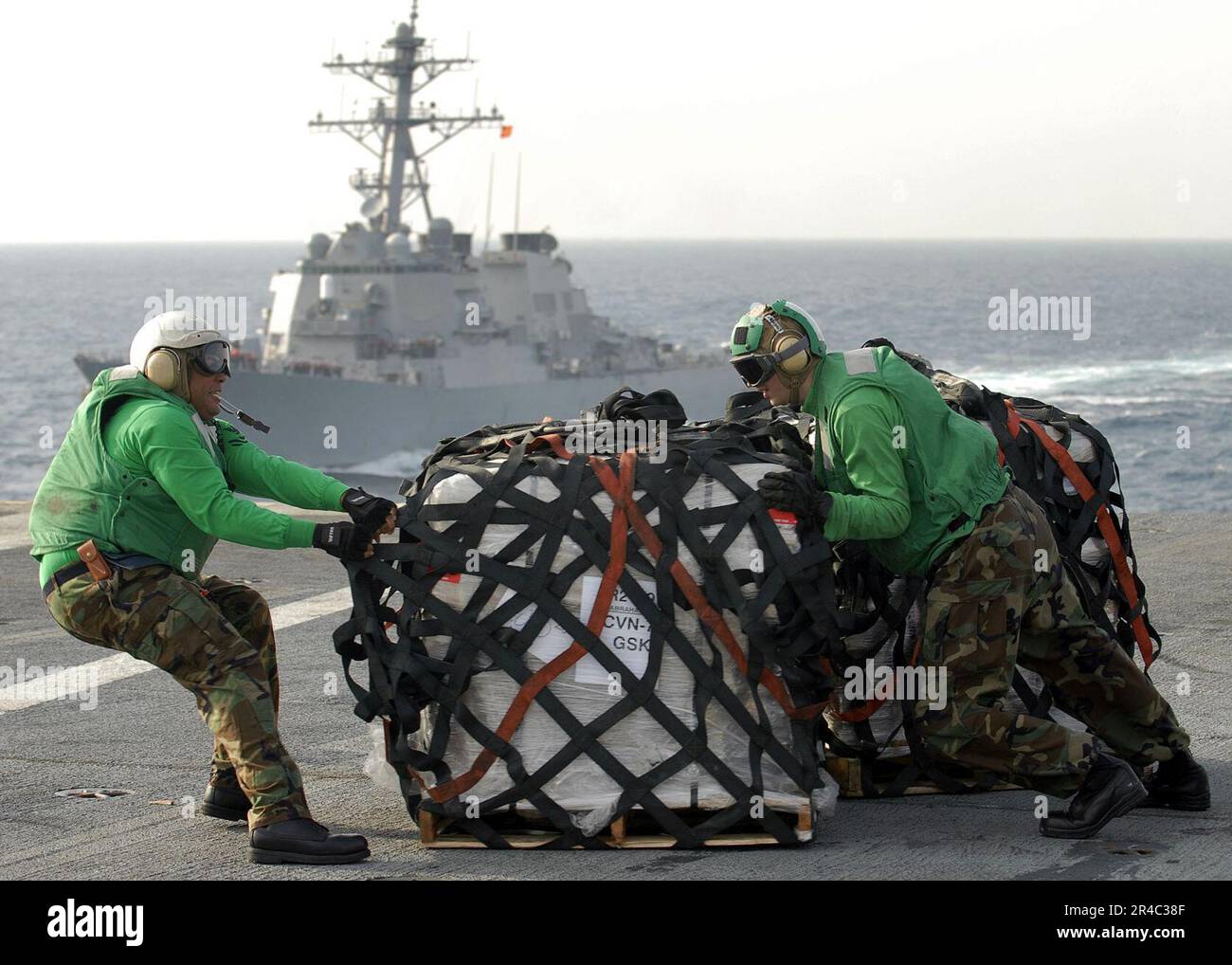 US Navy Sailors move supplies on the flight deck aboard the Nimitz ...