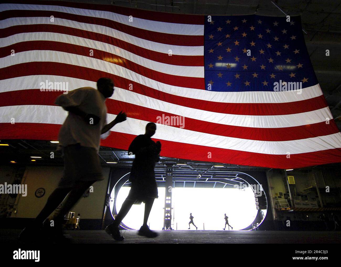 US Navy Sailors run laps in the hangar bay on board the nuclear-powered ...