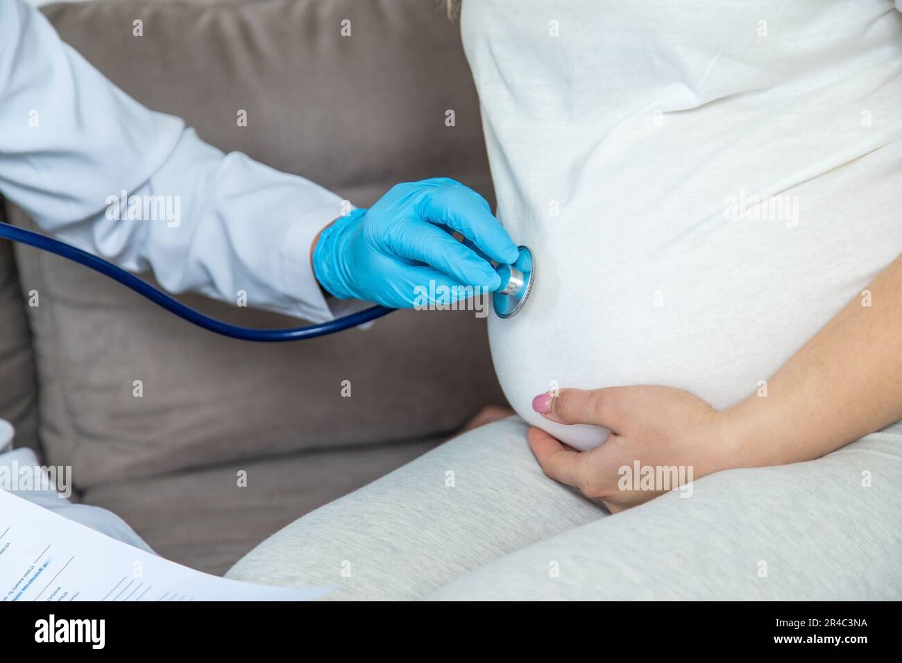 The doctor examines the belly of a pregnant woman. Selective focus ...