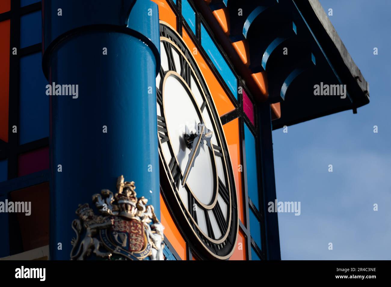 An upright blue post with an orange clock face mounted on its side ...