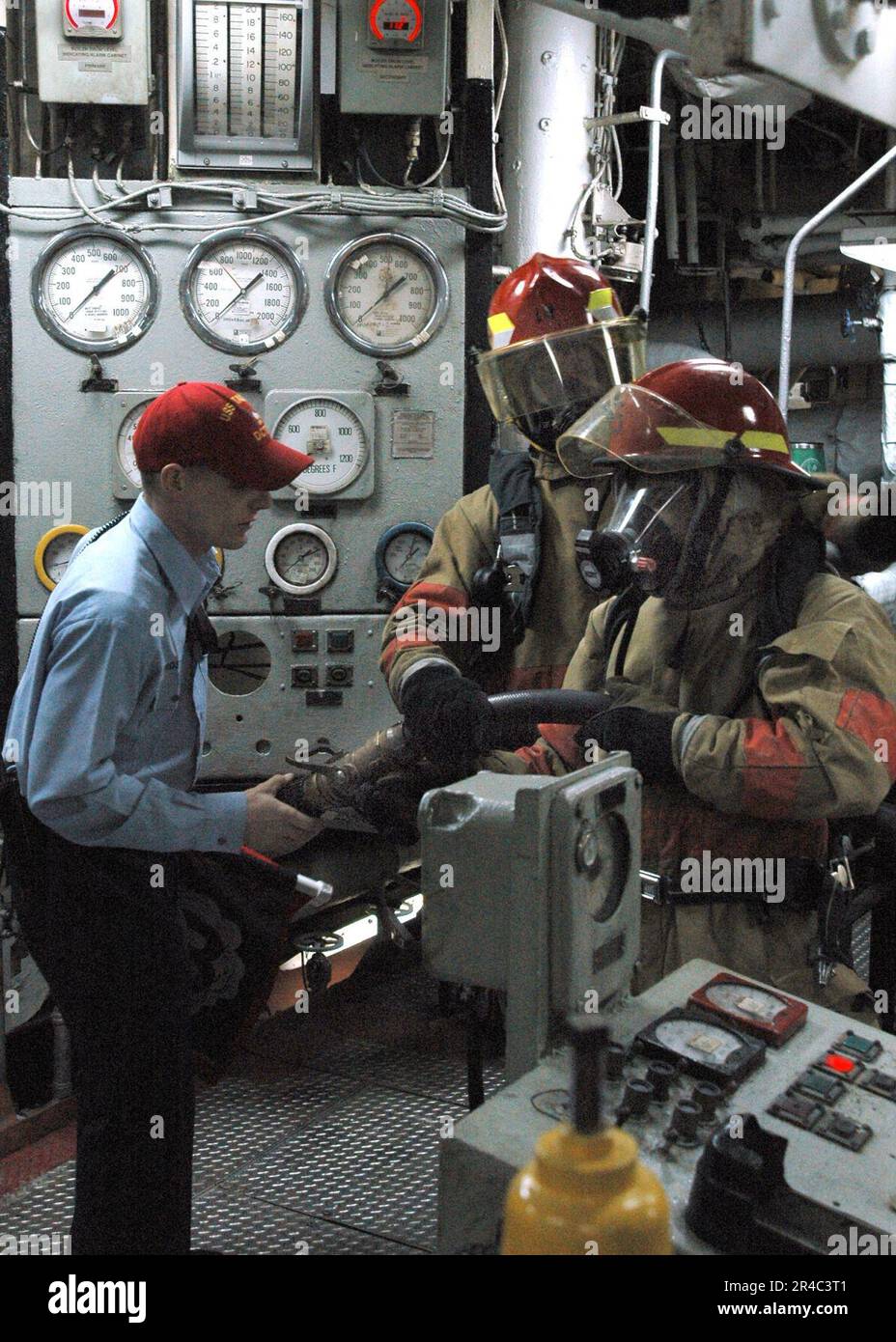 US Navy Damage Controlman 2nd Class instructs fire fighters in proper ...