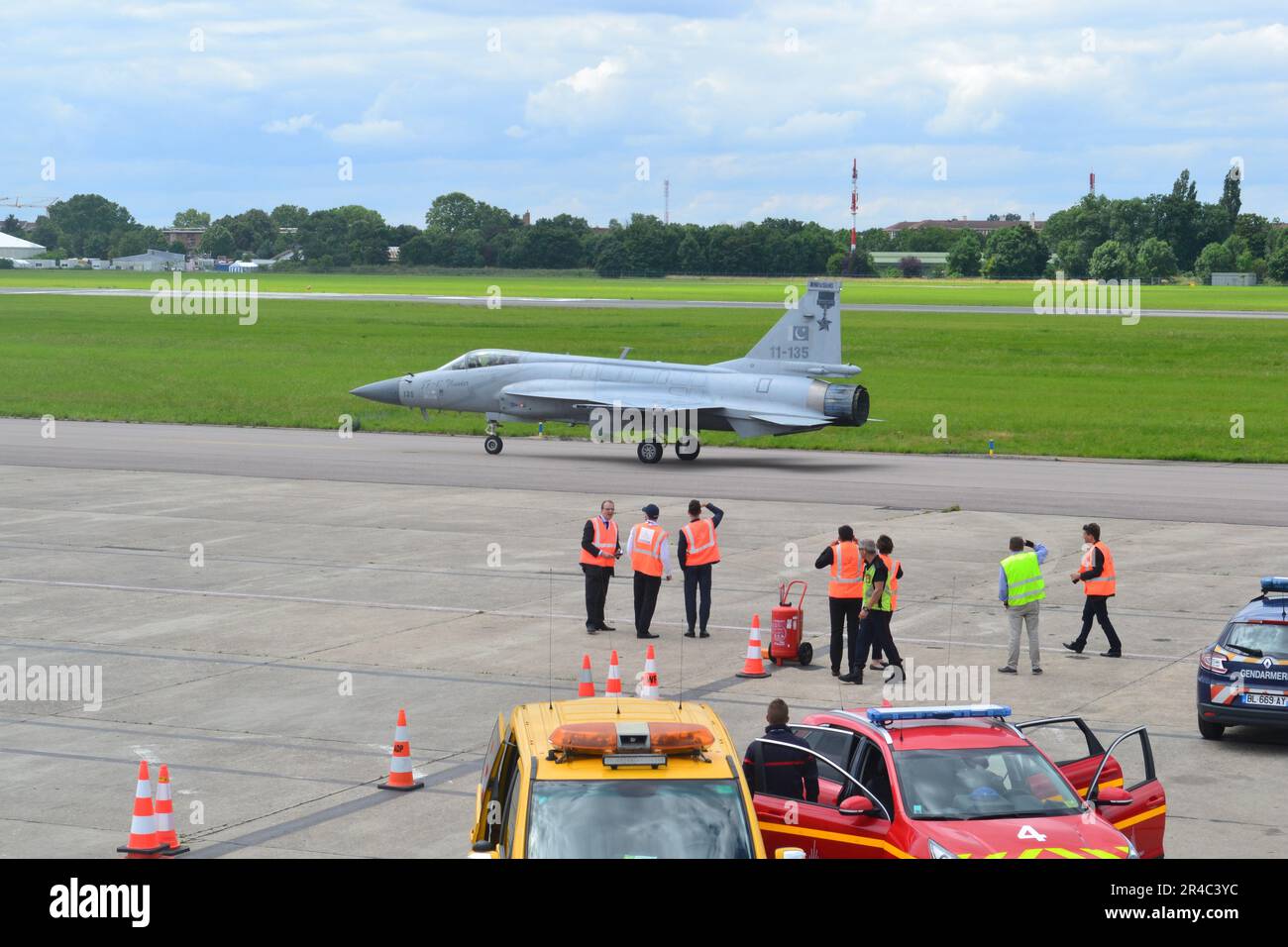 A commercial aircraft is parked on a runway, with multiple emergency ...