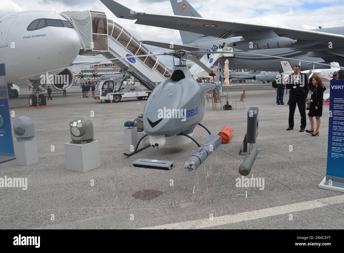 A diverse group of individuals gathered at an airport, standing in ...