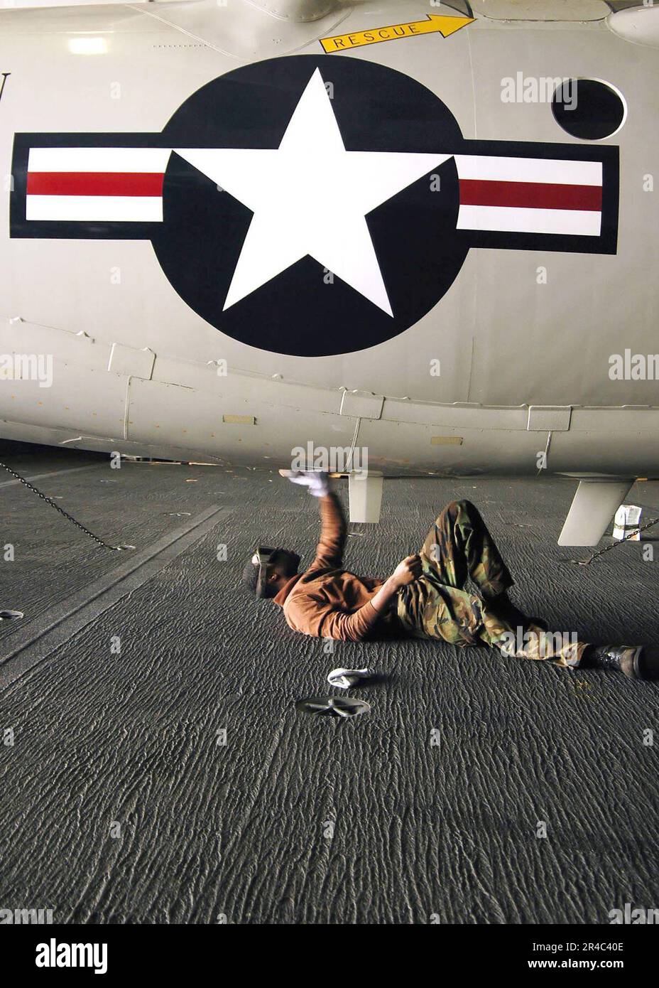 US Navy Airman cleans the underside of an E-2C Hawkeye assigned to ...