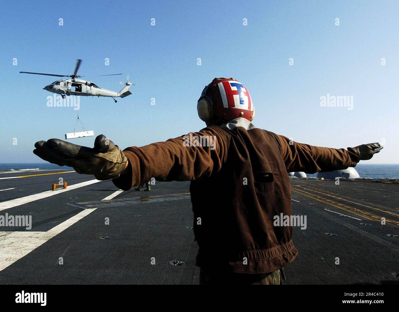 US Navy An Enlisted Landing Signalman gives the hover signal to the ...