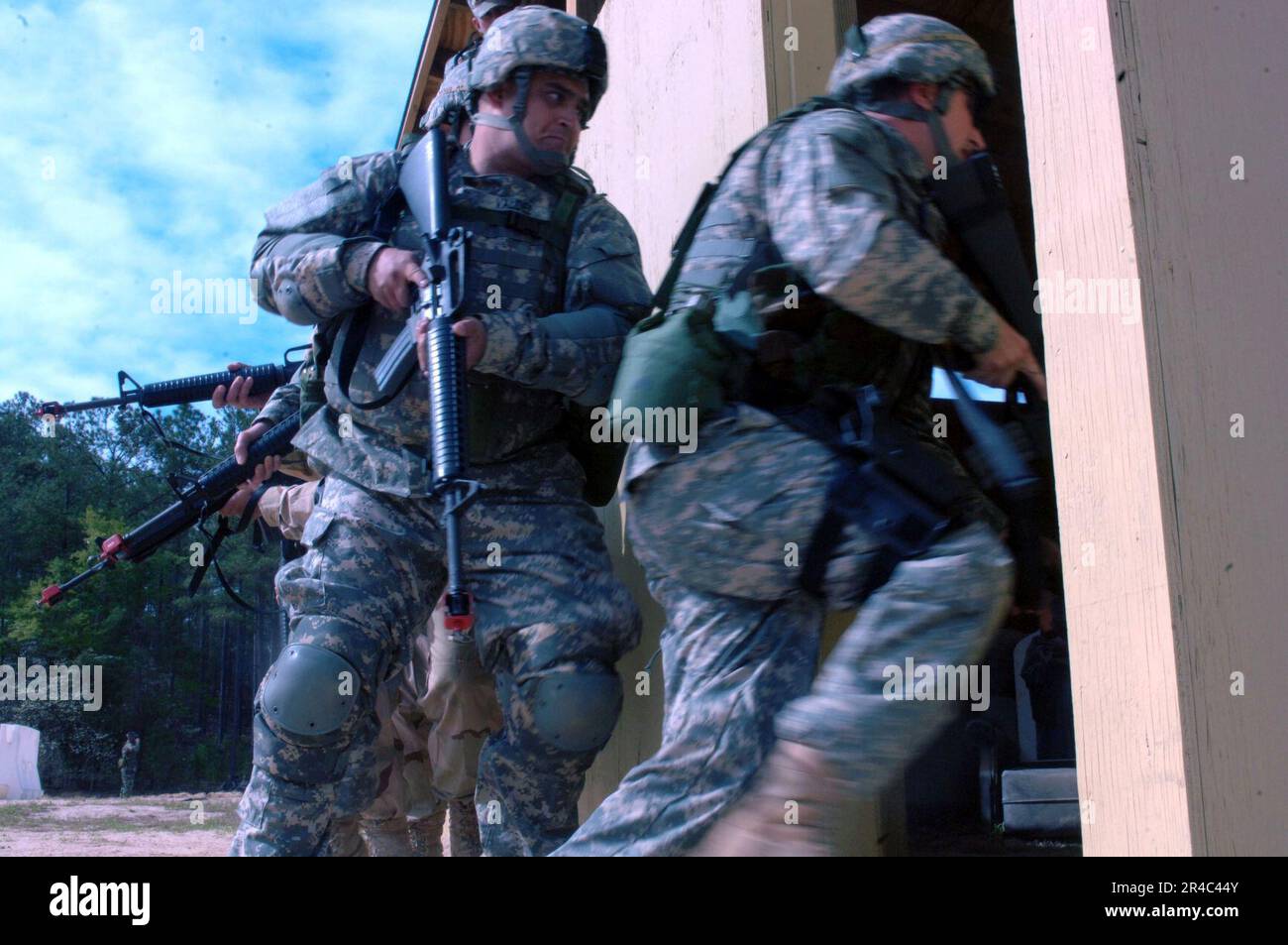 US Navy Sailors rush into a simulated building to conduct search and ...