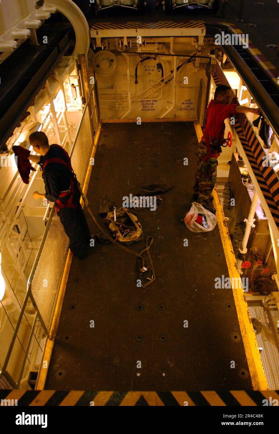 US Navy Machinist's Mate 3rd Class perform routine maintenance on an ...