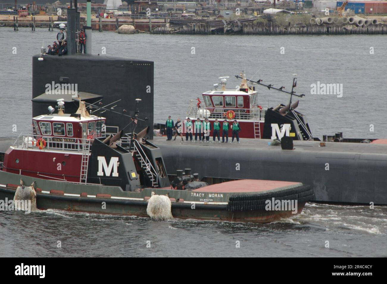 US Navy Crew-members stand topside as the guided-missile submarine USS ...