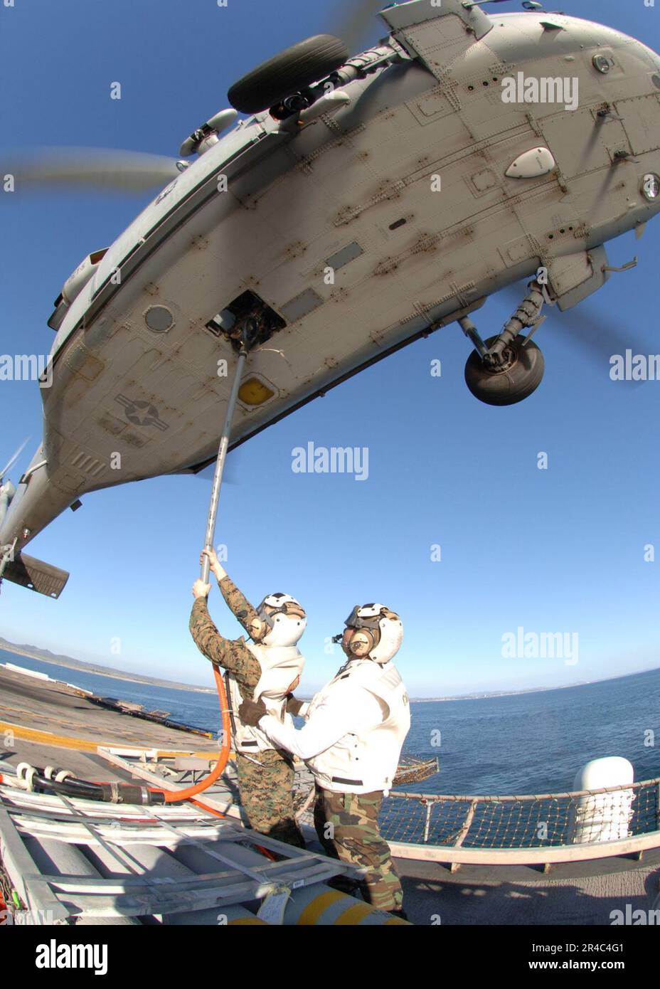 US Navy Staff Sgt. attaches a cargo pendant to an MH-60S Seahawk ...