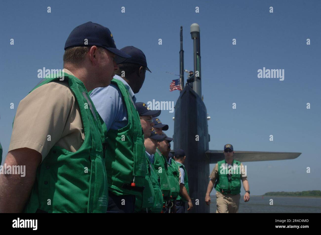US Navy Topside line handlers stand in a line as part of the ...