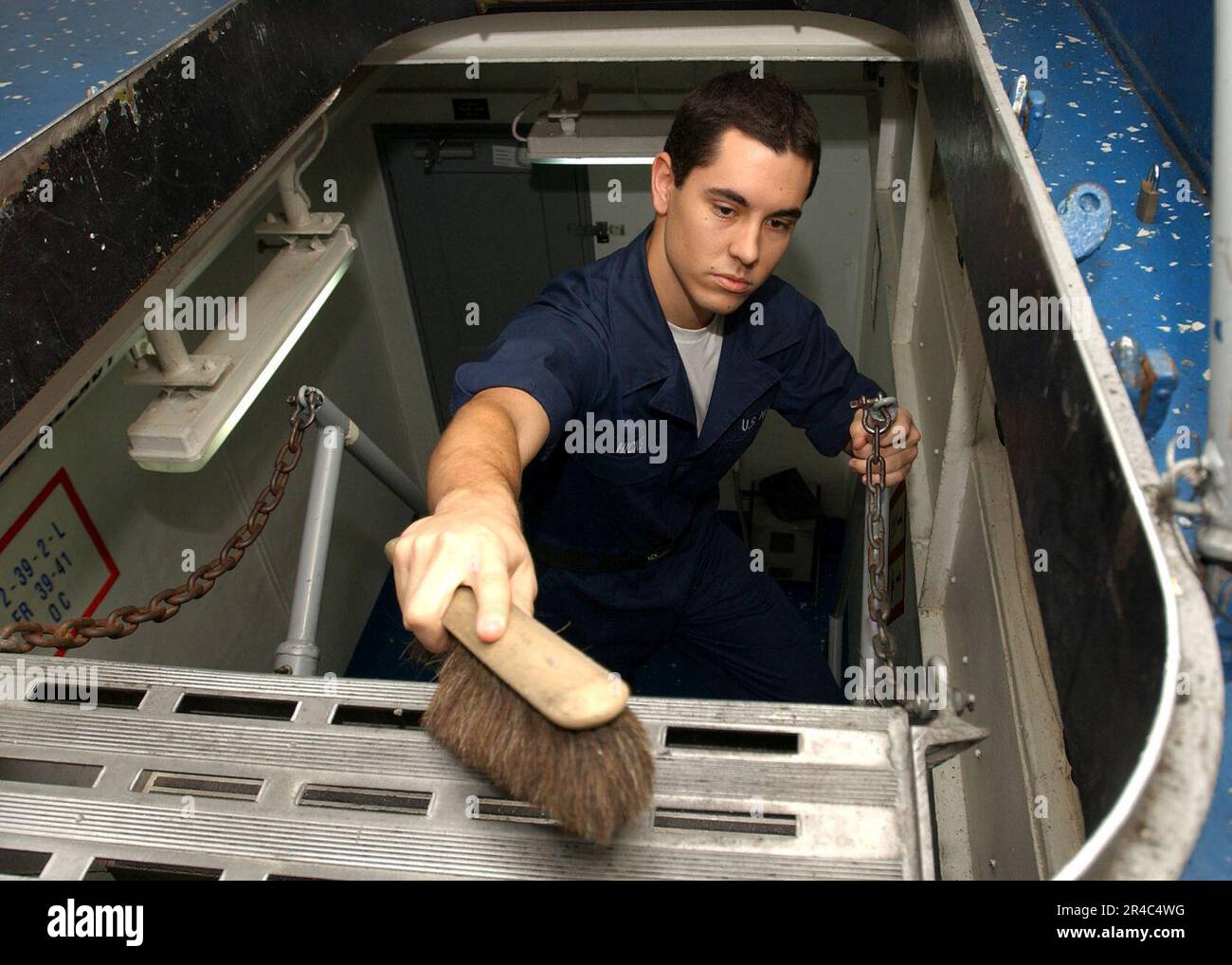 US Navy Air Traffic Controller Airman Apprentice sweeps off a ladder ...