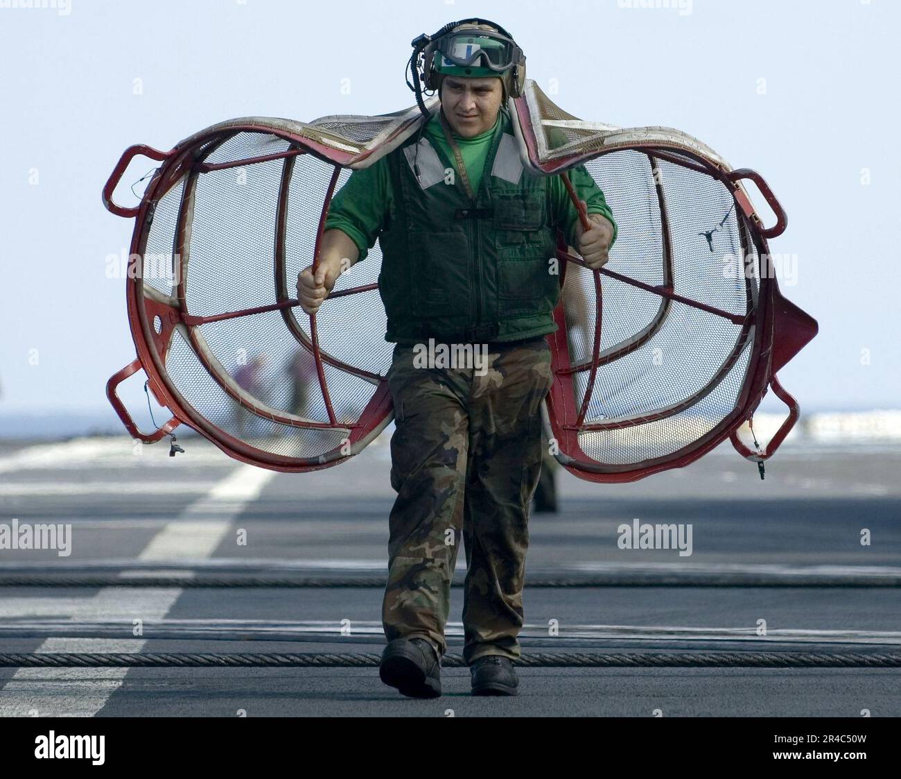 US Navy A Sailor assigned to Air Department carries intake duct screens ...