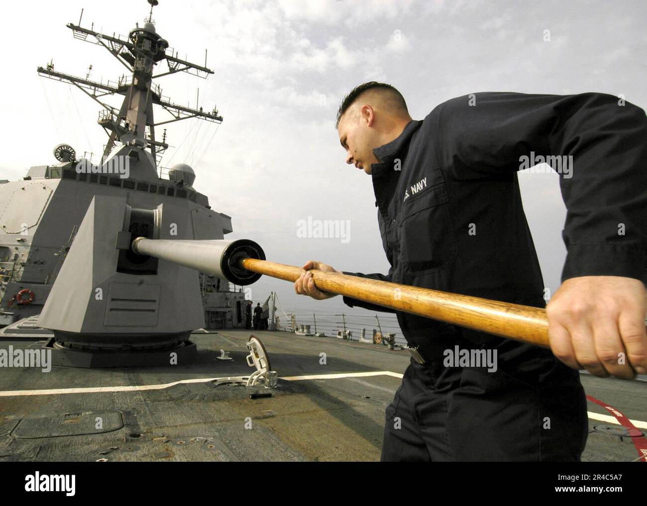 US Navy Gunner's Mate 2nd Class cleans the barrel of an MK-45 5-inch-54 ...
