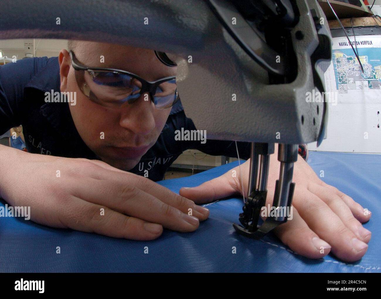 US Navy Aircrew Survival Equipmentman Airman stitches a sentry tent for ...