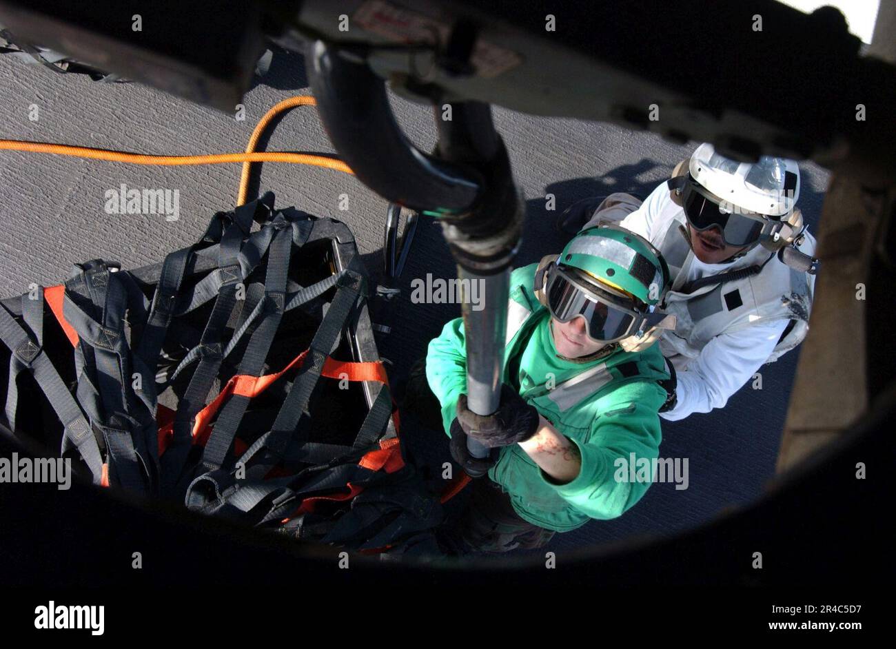 US Navy A Sailor and his spotter latches a cargo pendant to the bottom ...
