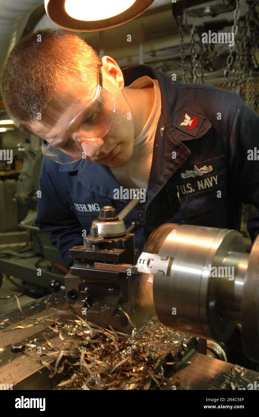 US Navy Machinery Repairman 2nd Class repairs a valve using a lathe ...