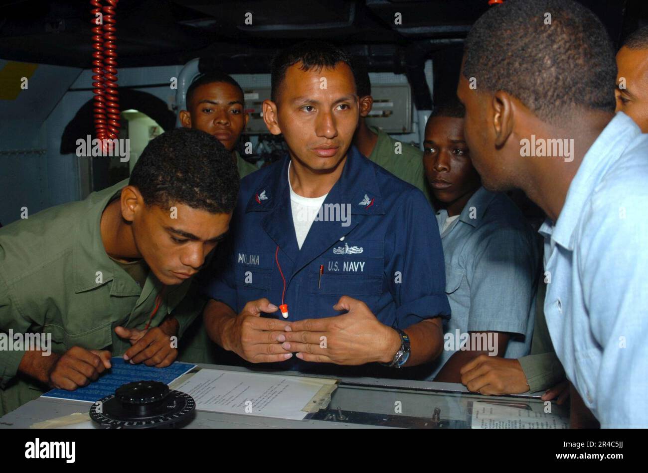 US Navy Ship's Serviceman 3rd Class explains to members of the ...
