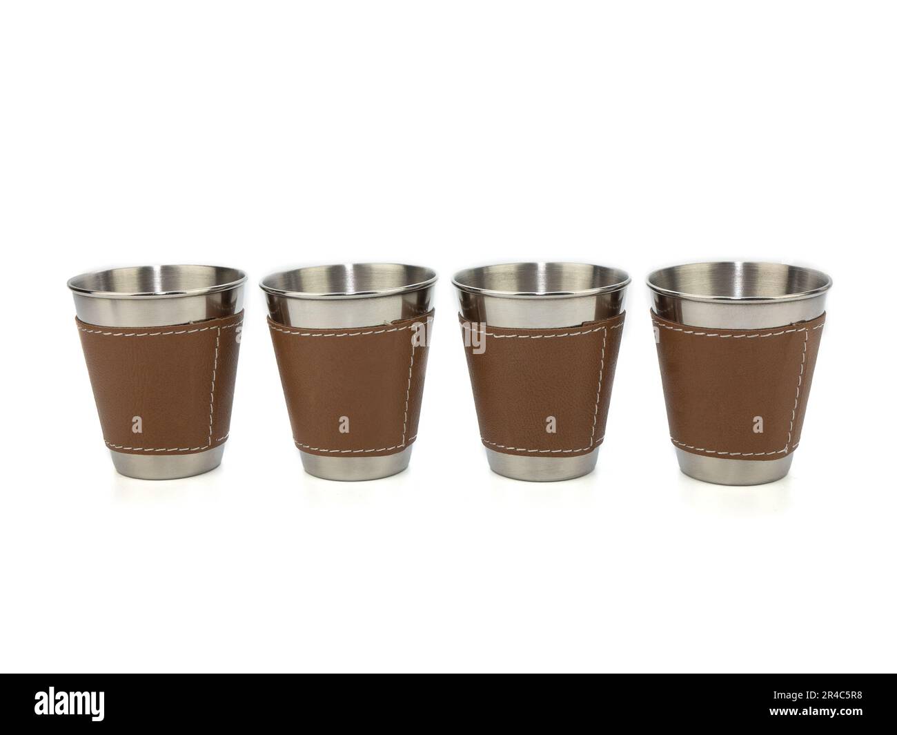 Four steel cups with leather trim in a row, isolated on the white ...
