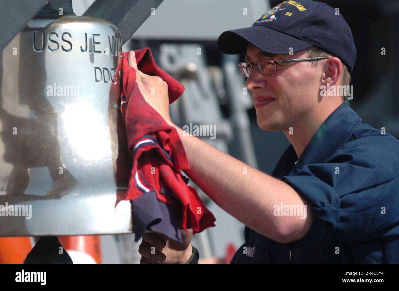 US Navy Seaman shines the bell on the guided-missile destroyer USS ...
