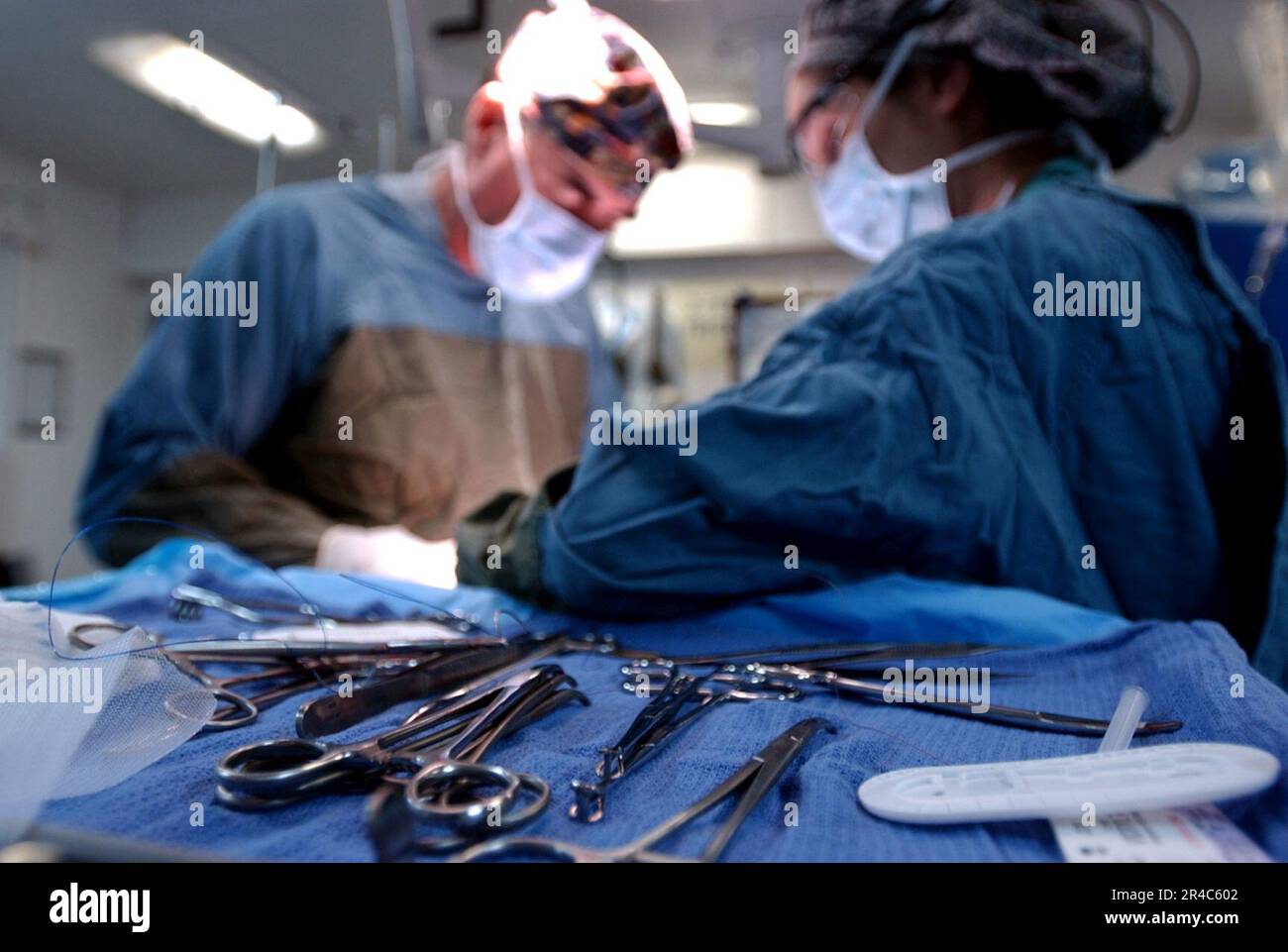 US Navy Cmdr. ship's surgeon, and Hospital Corpsman 1st Class perform a ...