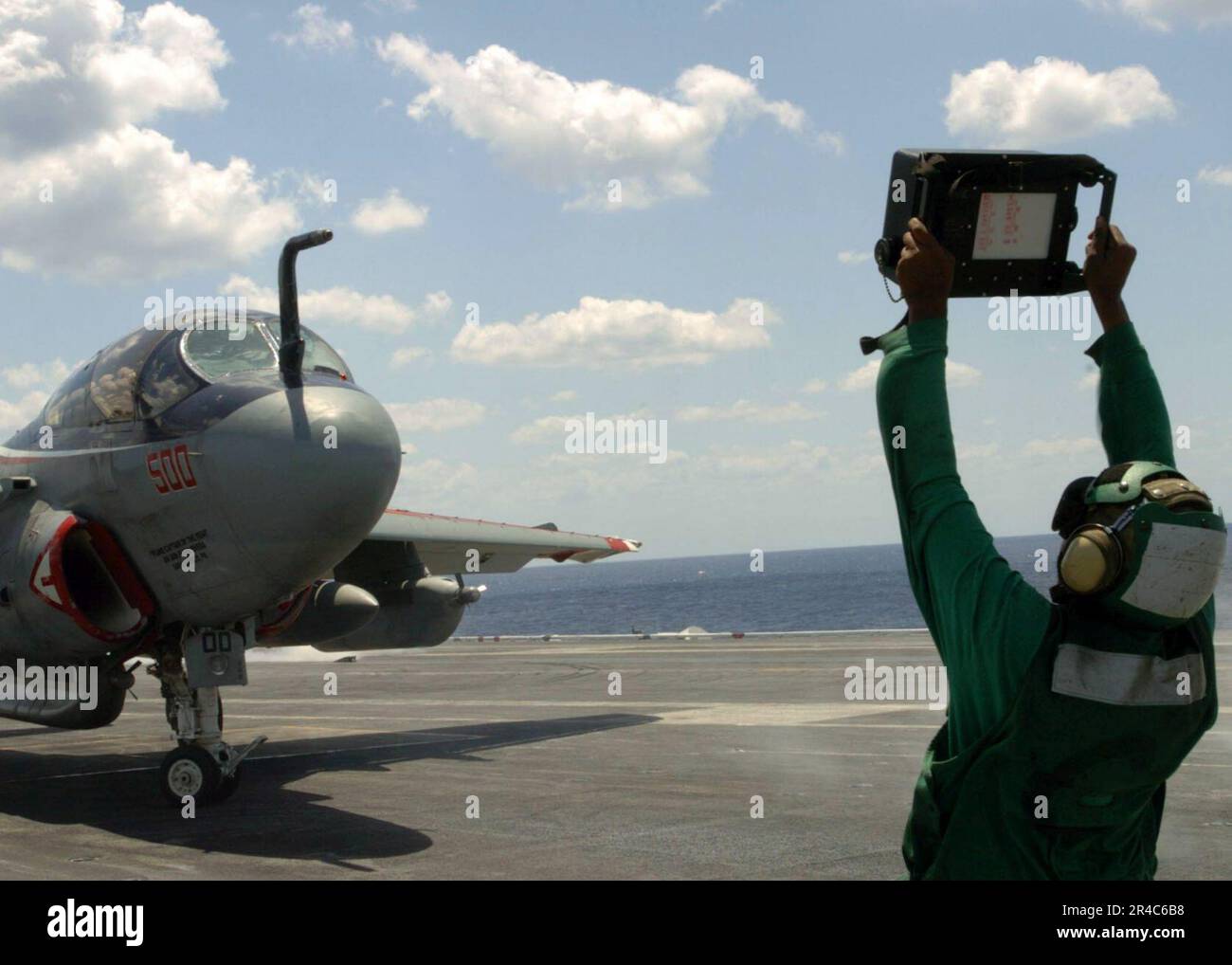 US Navy A Sailor holds up a weight board to the pilot of an EA-6B ...