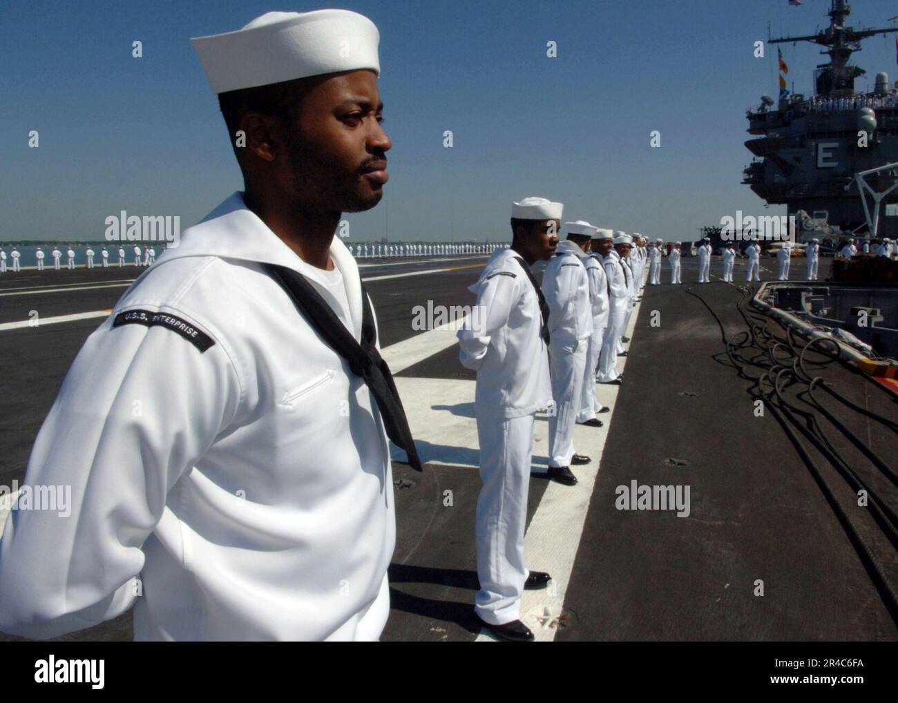 US Navy Sailors man the rails on the flight deck of the nuclear-powered ...