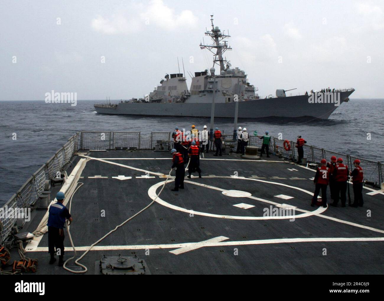 US Navy Boatswain's mates heave lines as the guided-missile destroyer ...