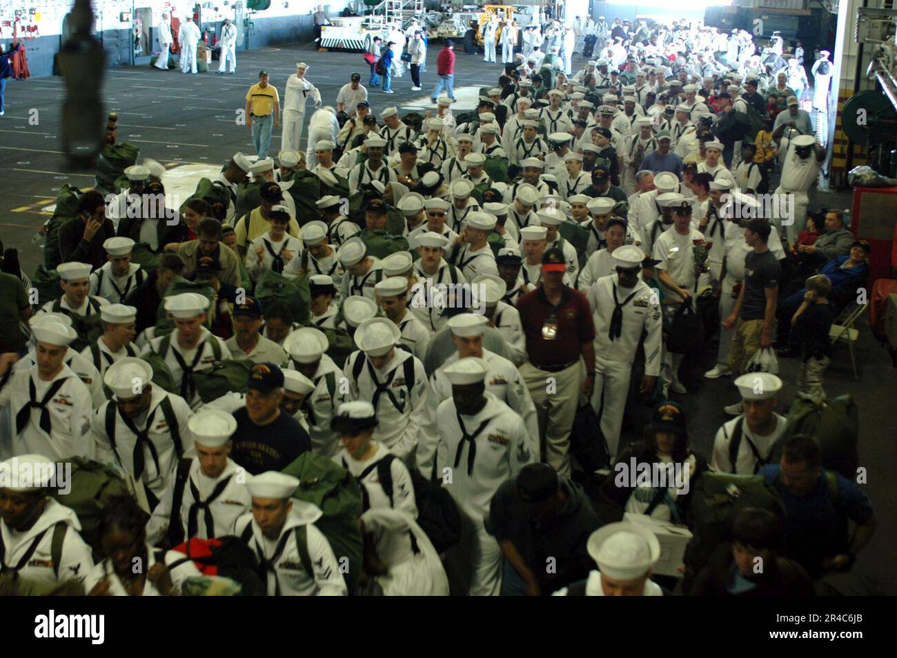 US Navy Sailors and family members depart the amphibious assault ship ...
