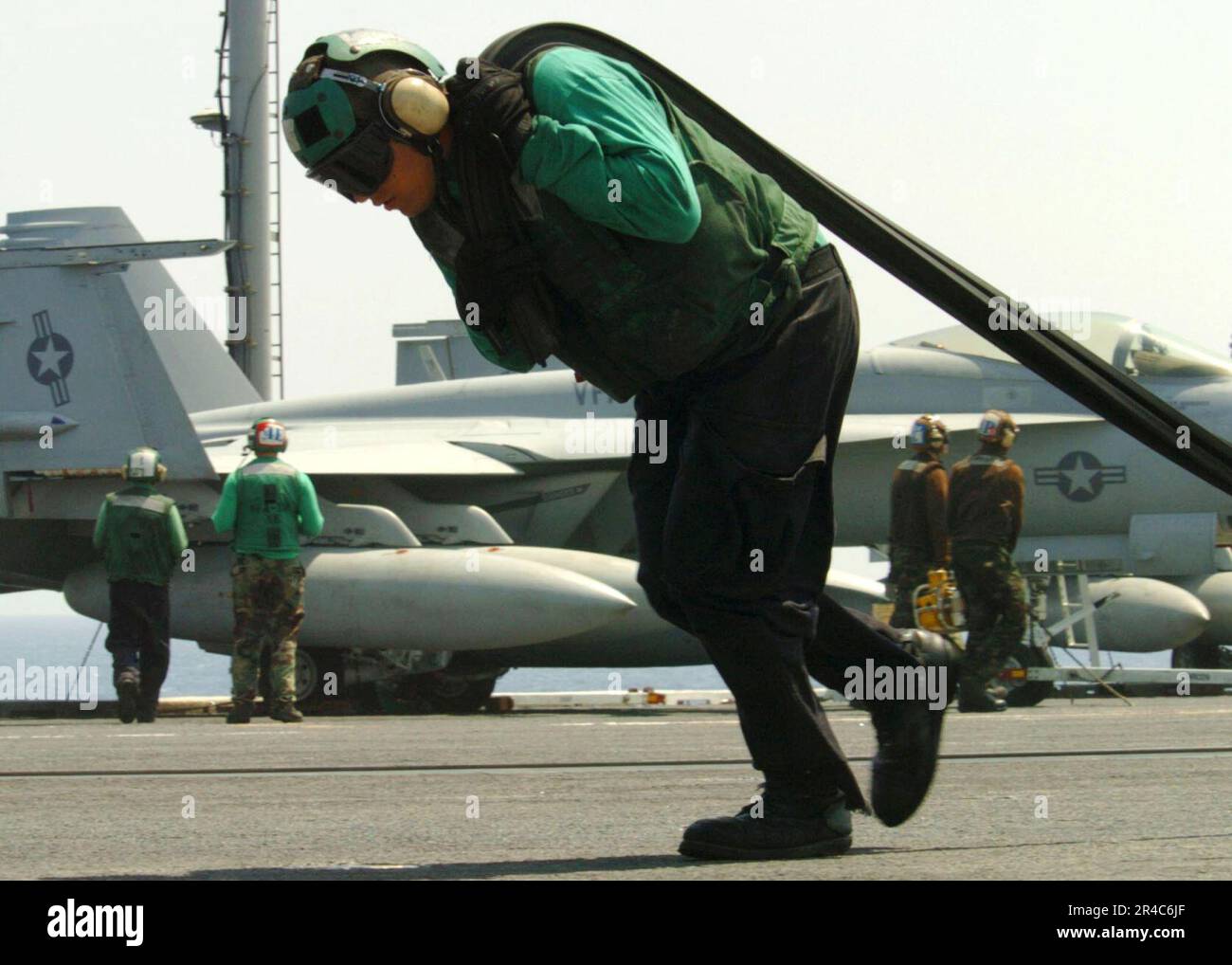 US Navy A Sailor removes a catapult seal from the flight deck in ...