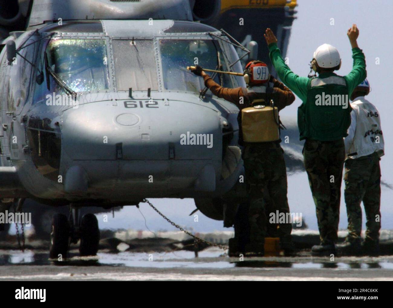 US Navy A Sailor washes the windshield of an SH-60 Seahawk helicopter ...