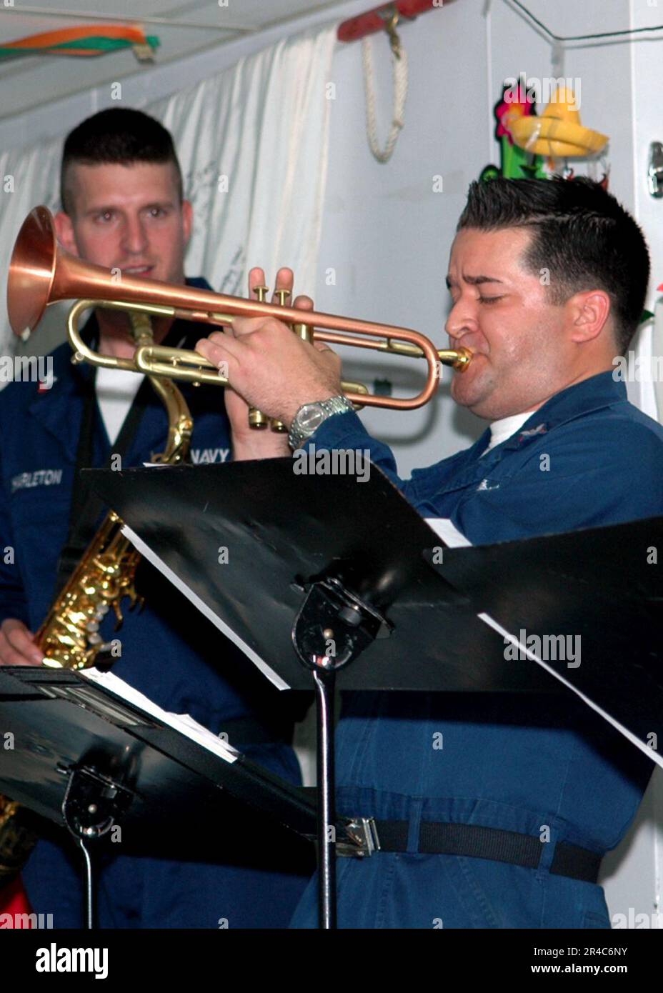 US Navy Musician 2nd Class plays the trumpet on the mess decks aboard ...