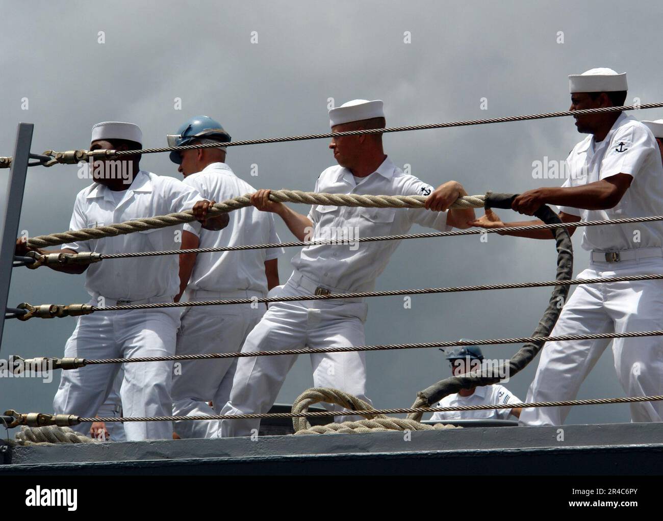 US Navy Sailors heave around on a mooring line as guided-missile ...