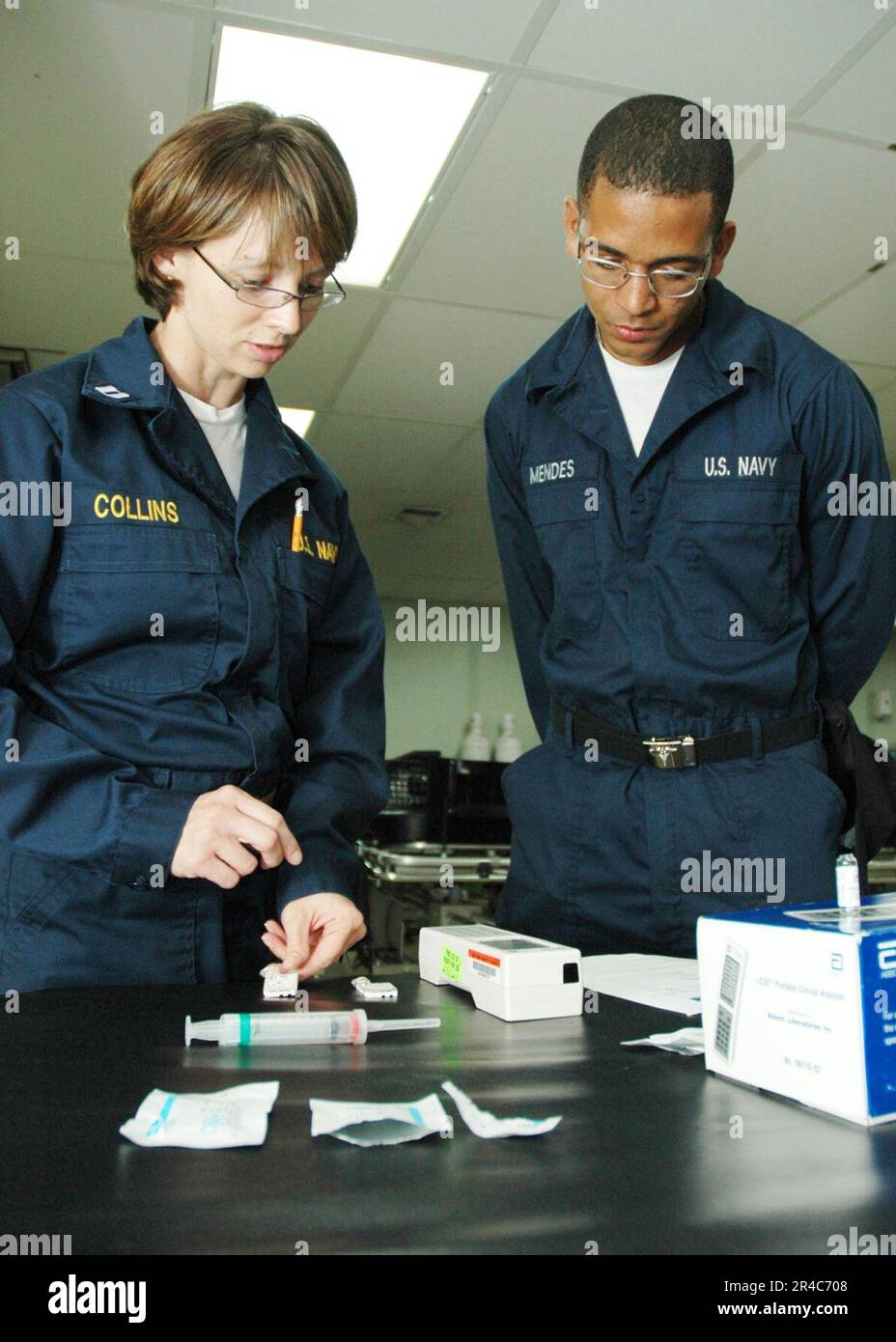 US Navy Lt. teaches Hospitalman proper procedures on testing a patient ...