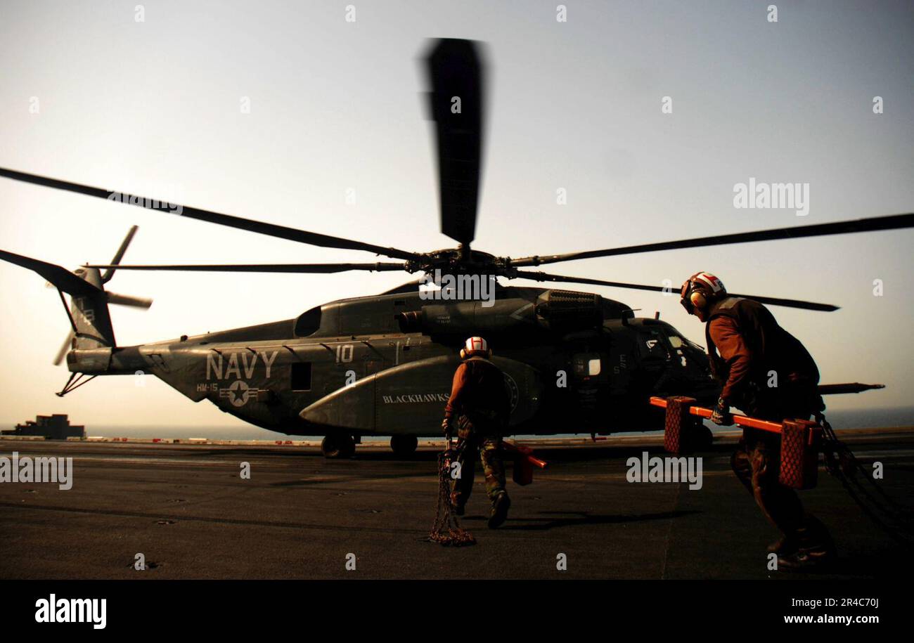 US Navy Flight deck personnel race forward with chocks and chains to ...
