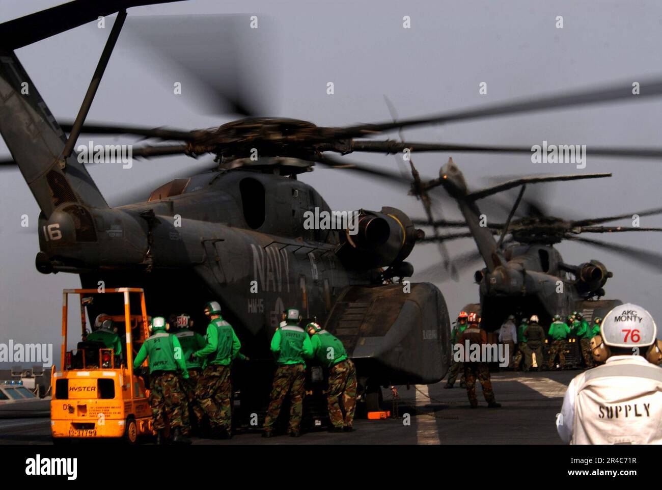 US Navy Flight deck personnel unload an MH-53E Sea Dragon assigned to Helicopter Mine Support ...
